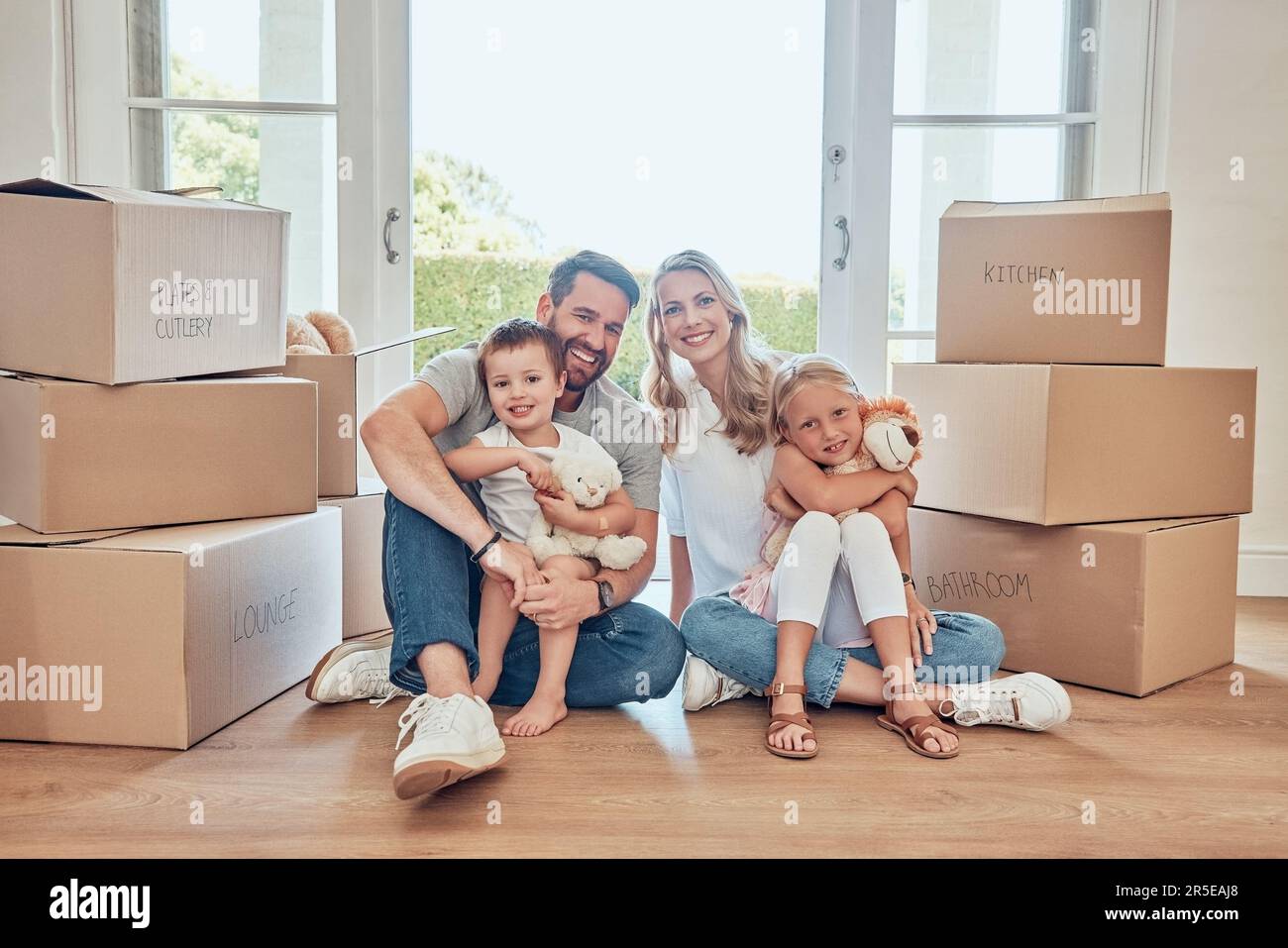 Portrait, parents and kids on floor of new house, real estate and ...