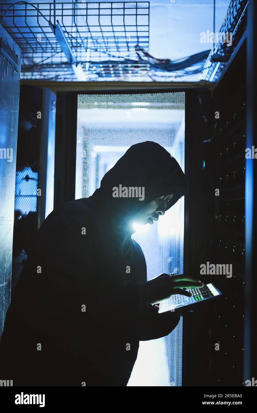 Hacking into your mainframe. a hacker using a digital tablet in a ...