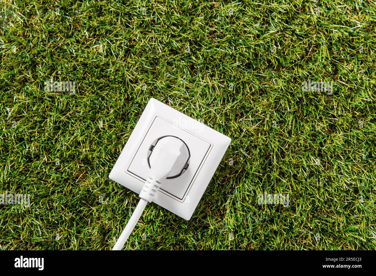 Green socket with power plug and cable on green grass hi-res stock ...