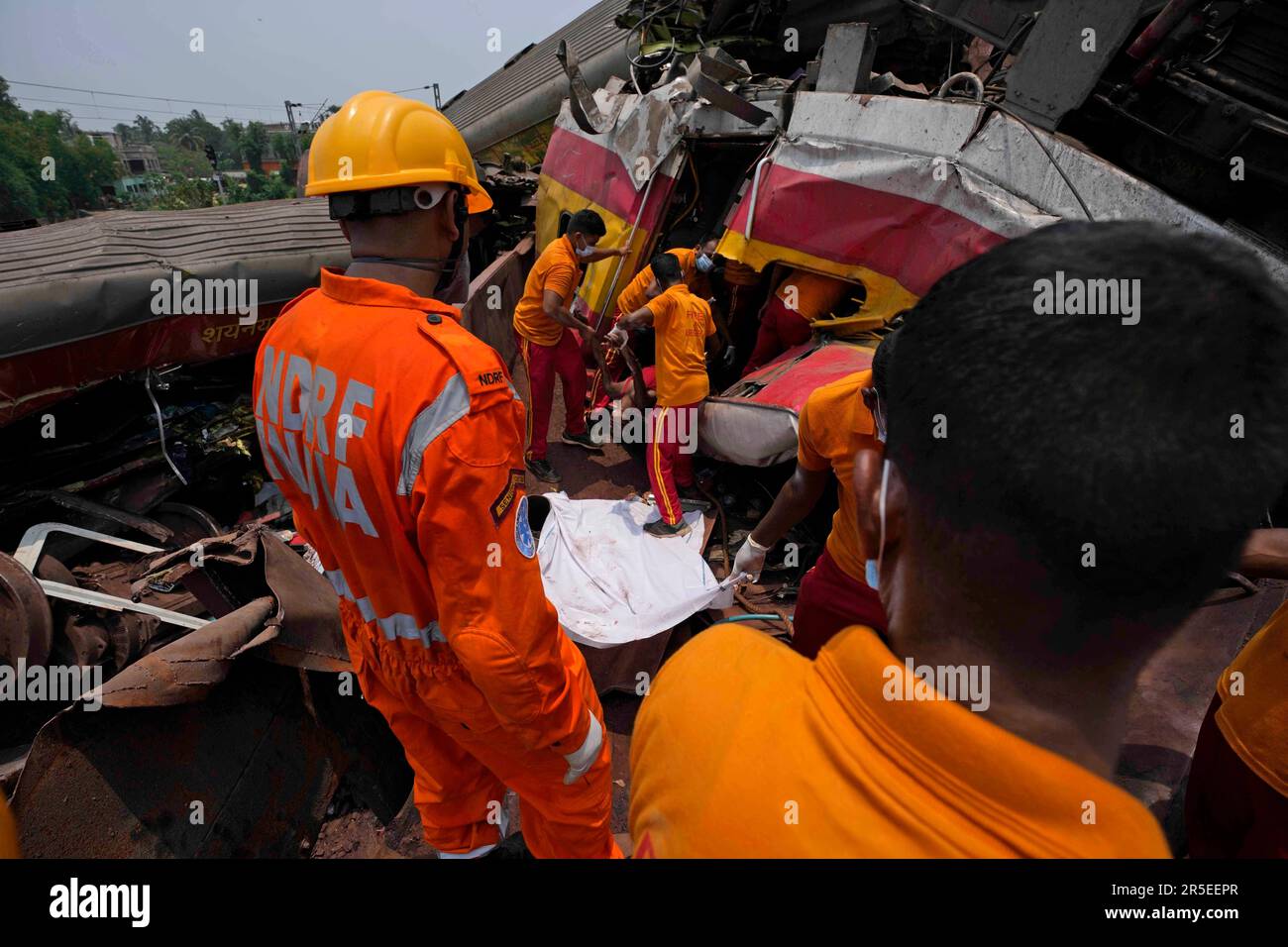 Rescuers carry the body of a victim of a passenger train that derailed in Balasore district, in ...