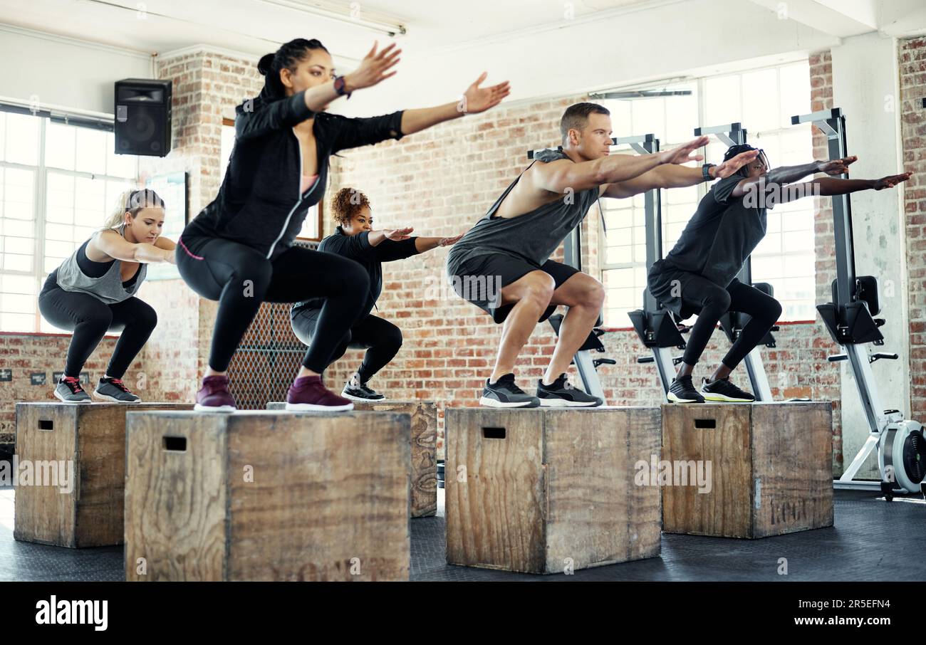 All about that fitness. a focused group of young people jumping onto ...