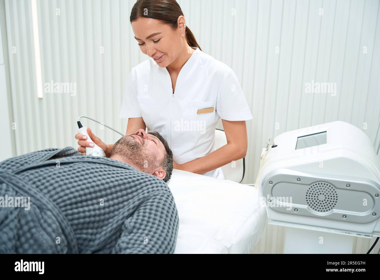 Woman in a professional uniform performs an RF lifting procedure Stock ...