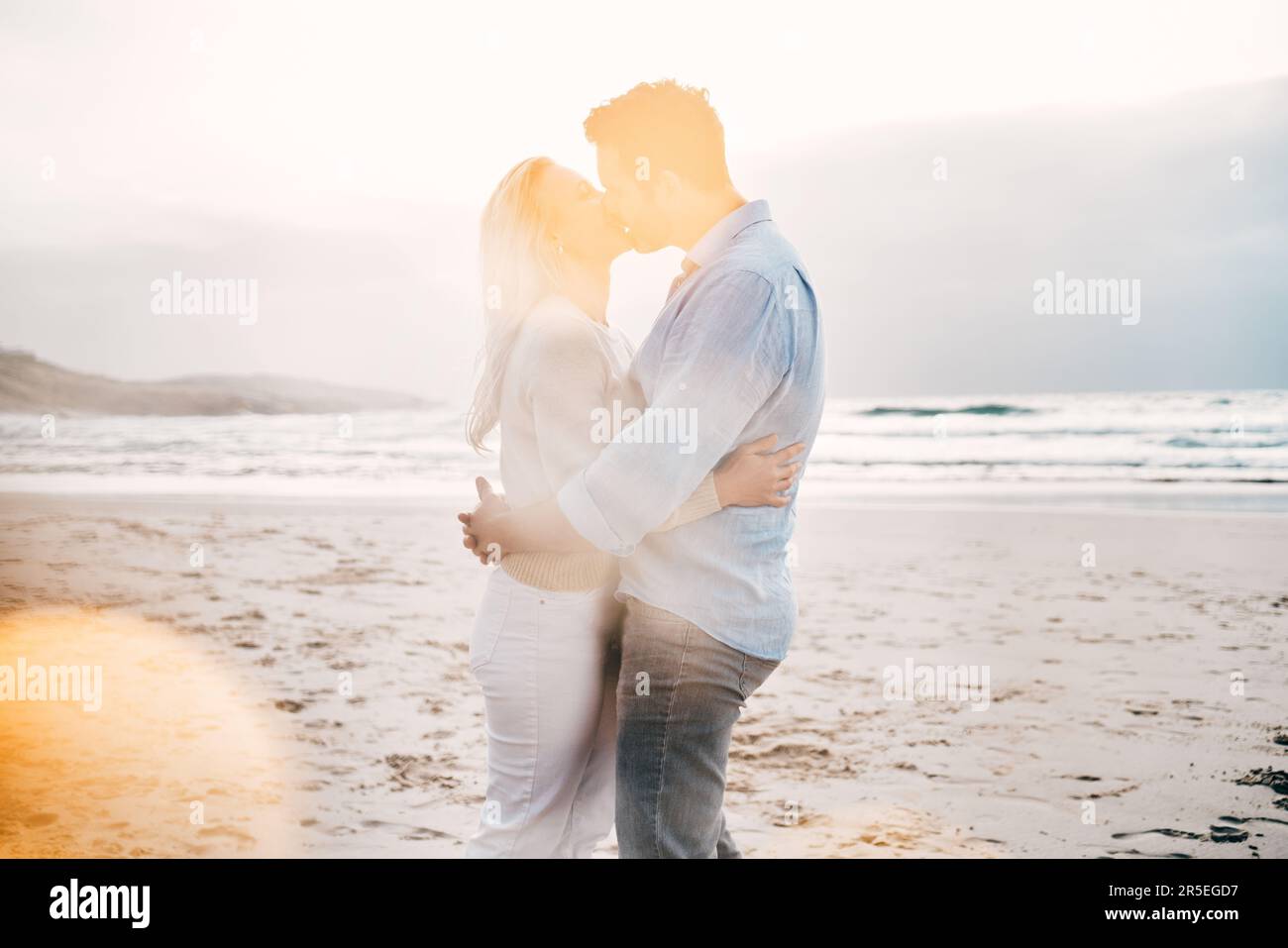 Beach, lens flare and couple kiss for love on holiday, vacation and ...