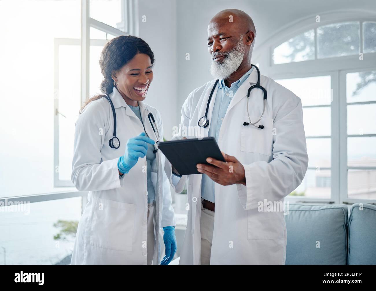 African doctors, teamwork and smile with tablet, comic or conversation ...