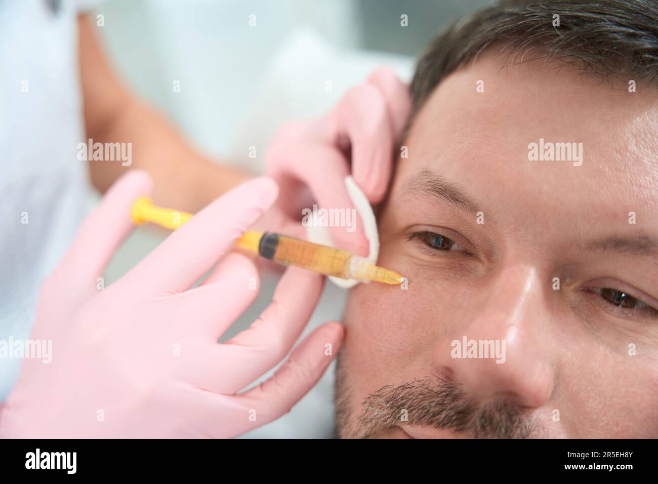 Male receives hypodermic injections in aesthetic medicine clinic Stock ...