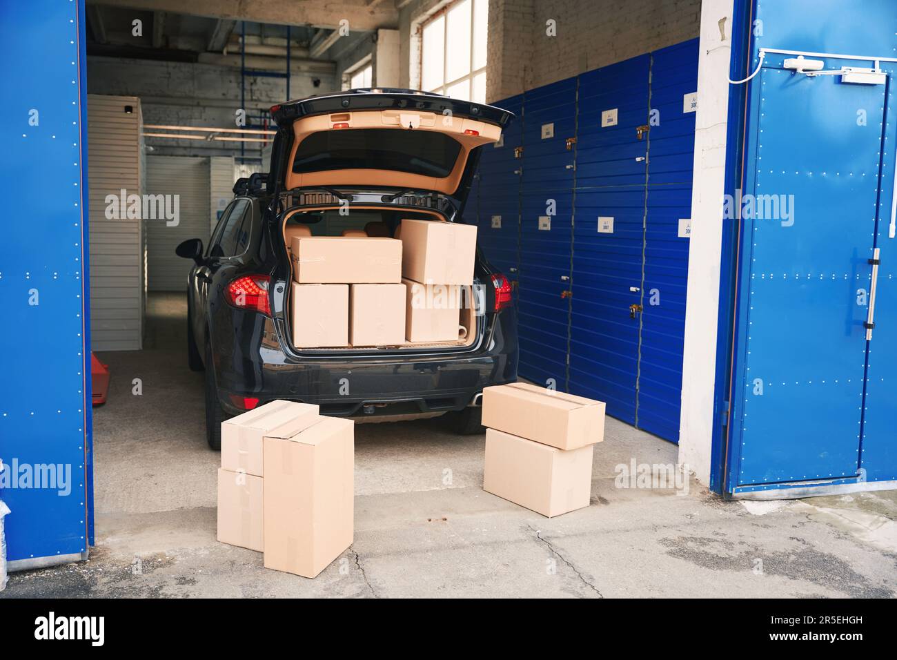 Car with cardboard boxes in the trunk into a warehouse with self ...