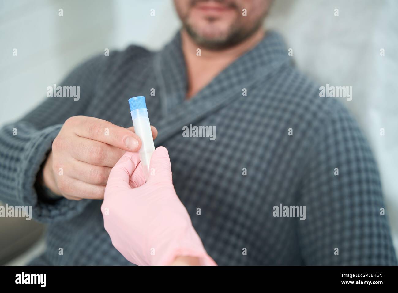 Patient takes a container with blood plasma from health worker Stock ...