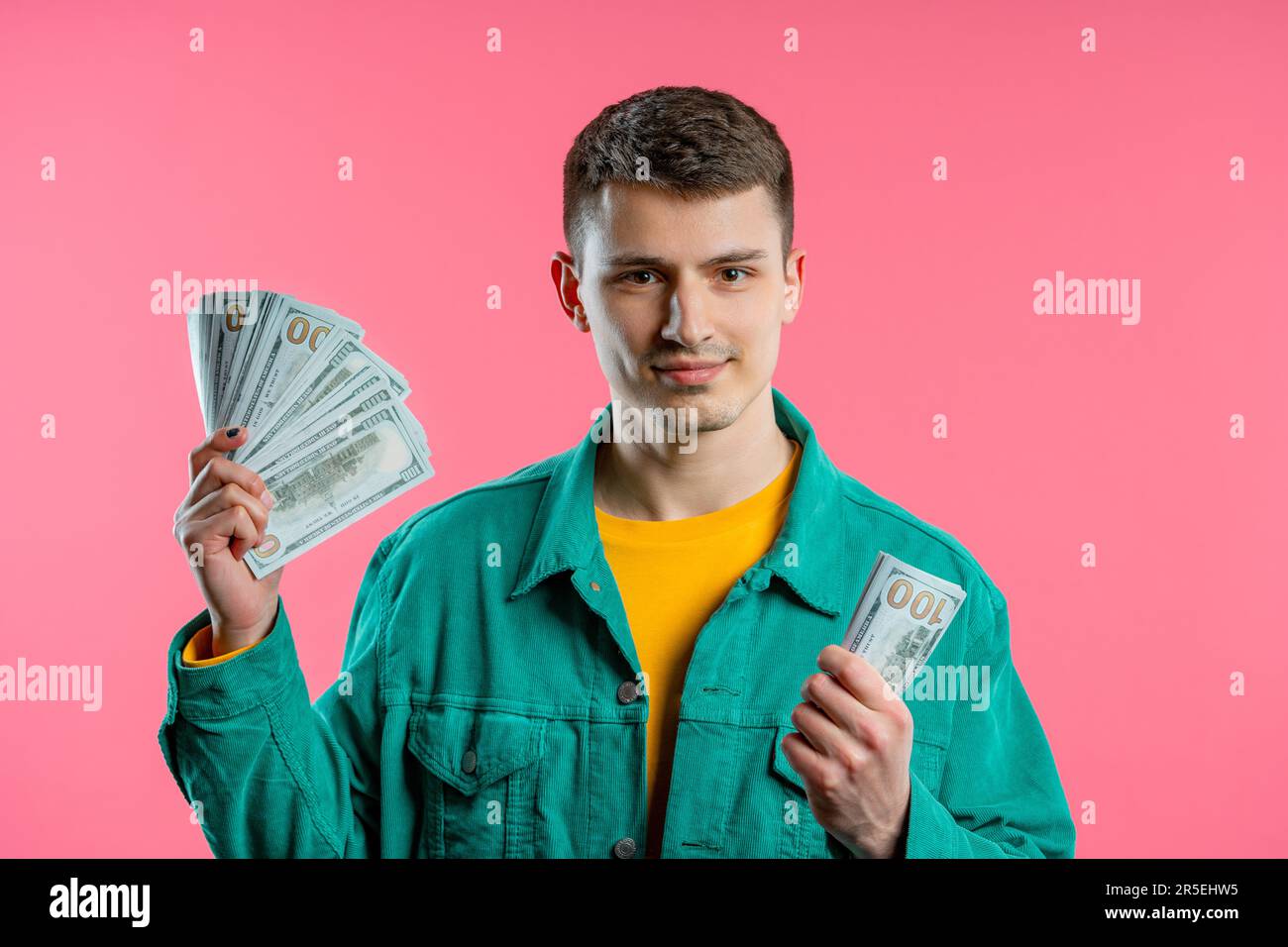 Rich excited young man with cash money USD currency dollars banknotes ...
