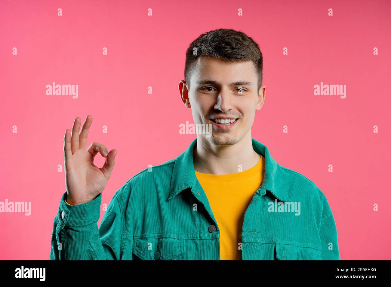 Positive man, OK hand sign, okay gesture. Happy guy on pink studio ...