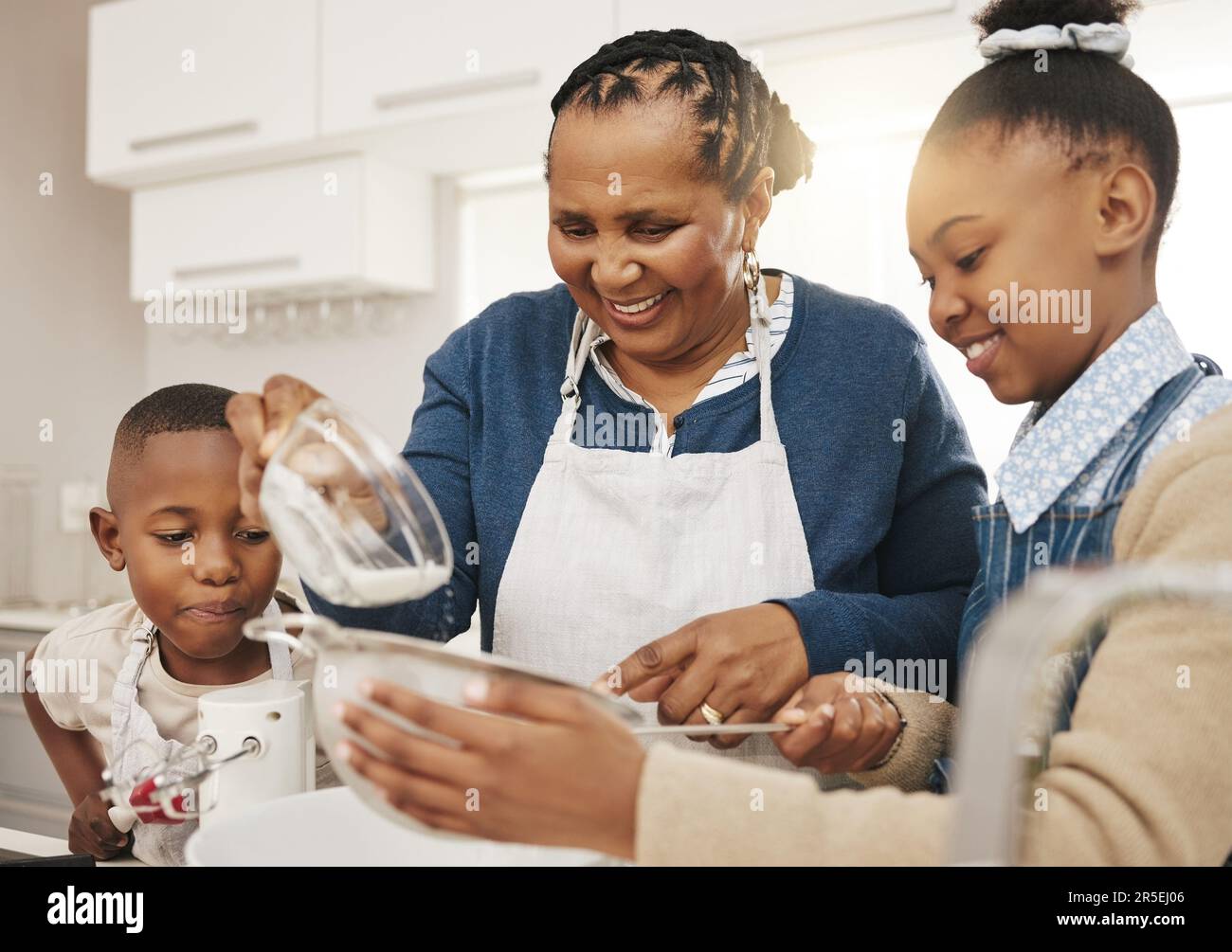 Happy family, grandmother teaching kids baking and learning baker skill in kitchen with help and ...