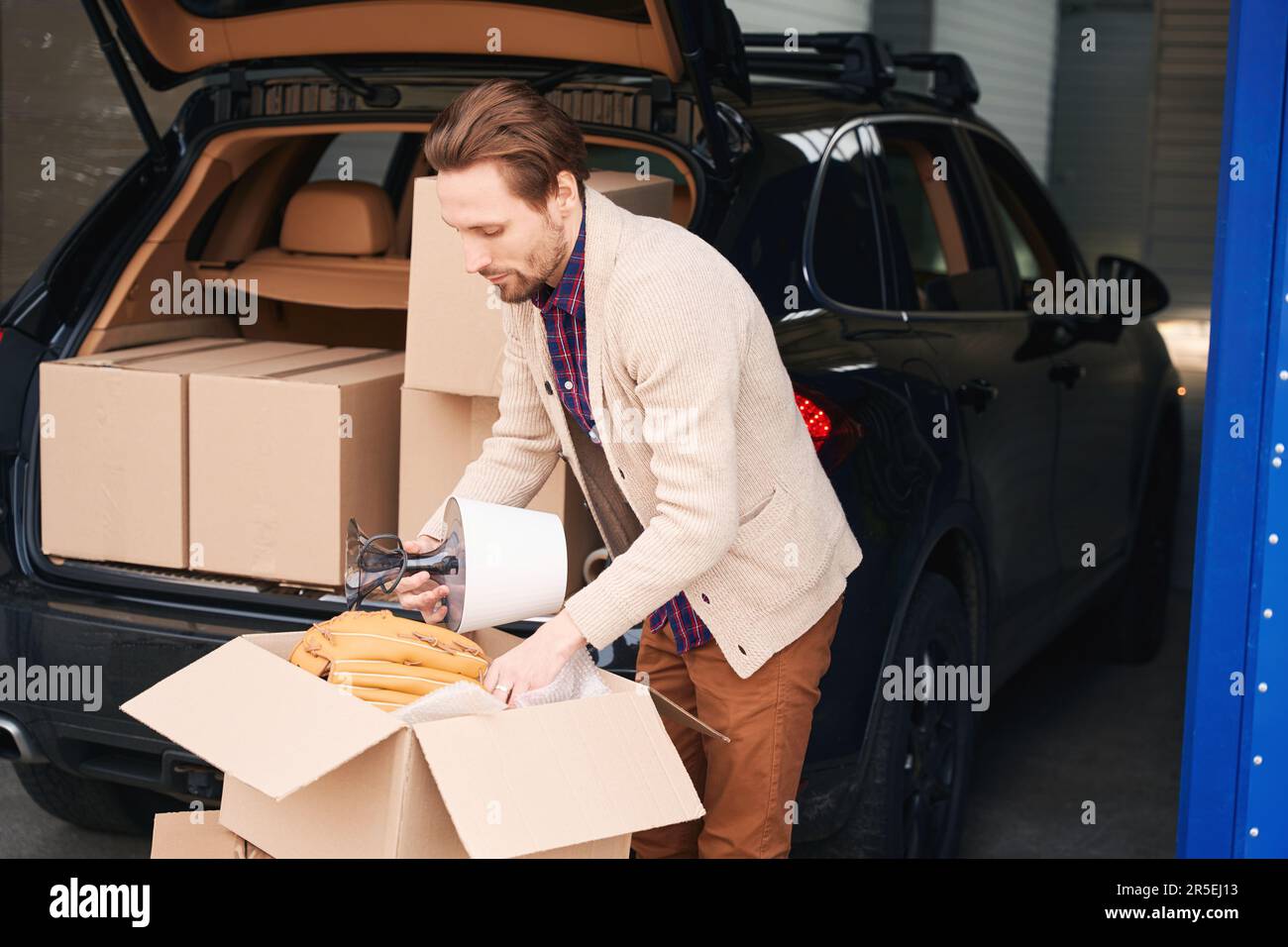 Male packing his things in cardboard boxes in the warehouse Stock Photo ...