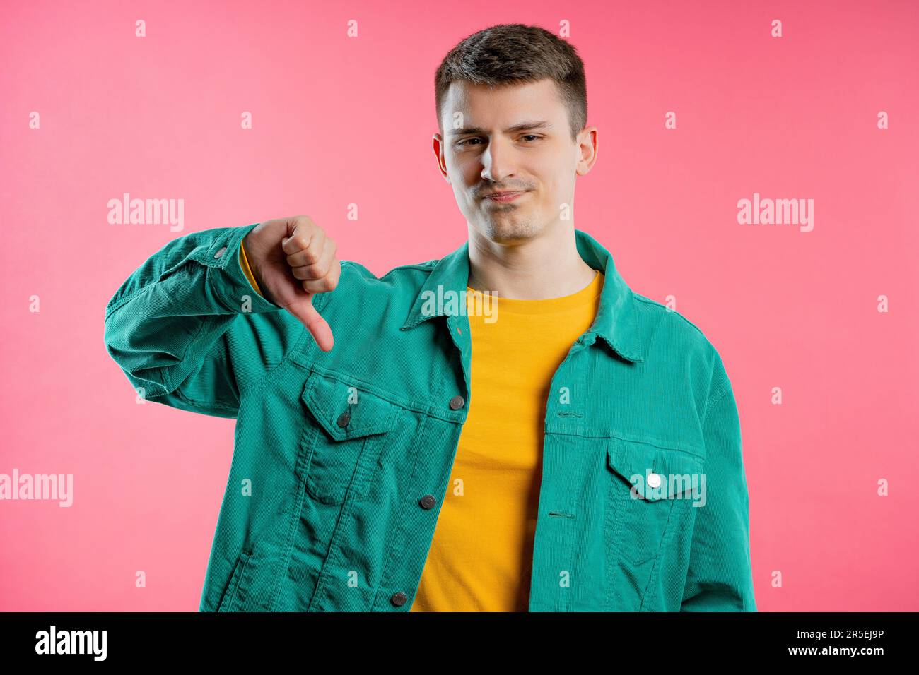 Young teenage guy with sign of dislike. European man expressing thumbs ...