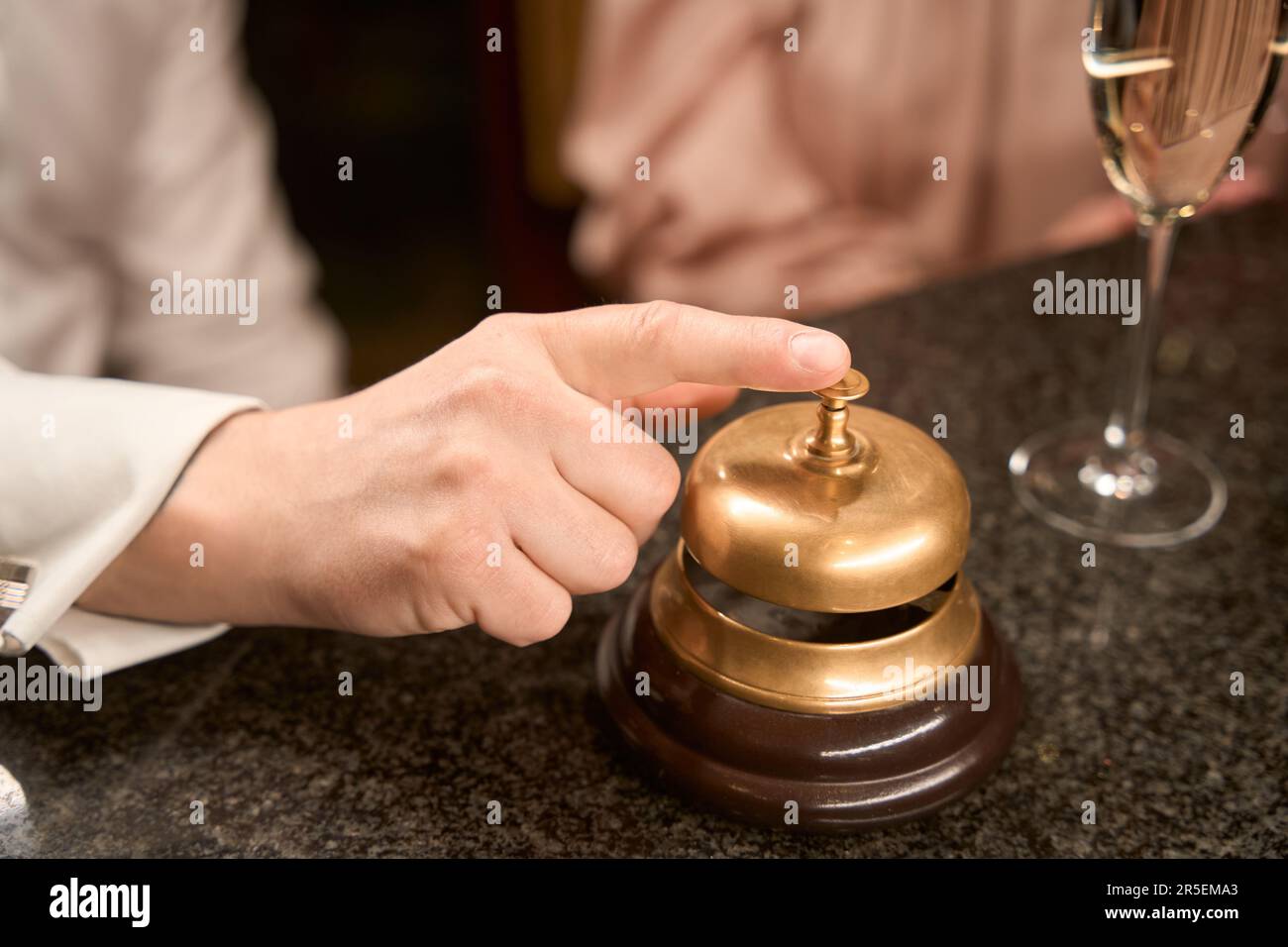 Male hand ringing golden service bell at counter desk in the bar Stock ...