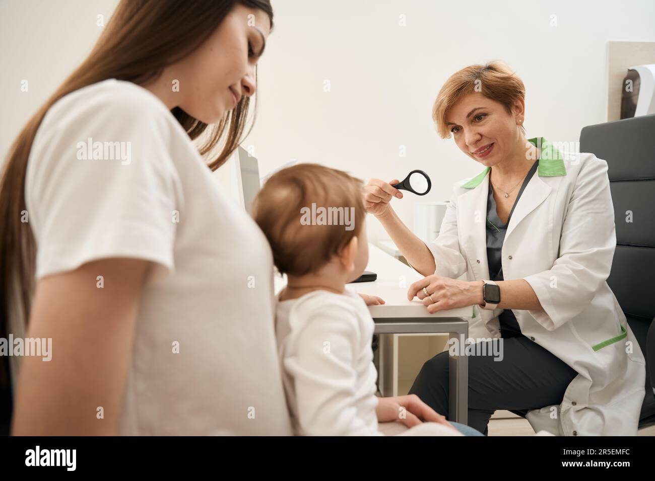 Qualified pediatric eye doctor checking child vision during primary ...