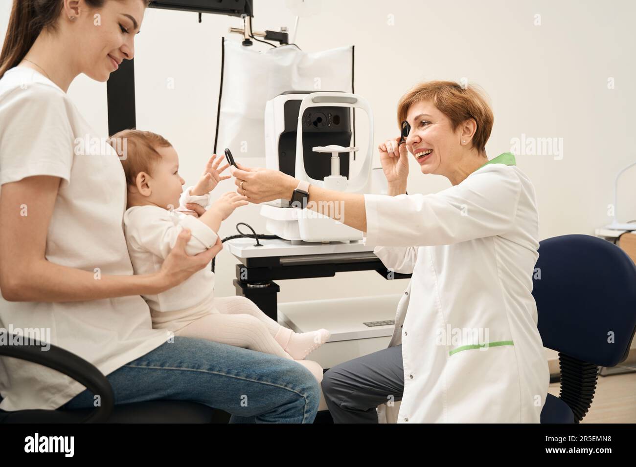Pediatric ophthalmologist examining little patient during initial ...