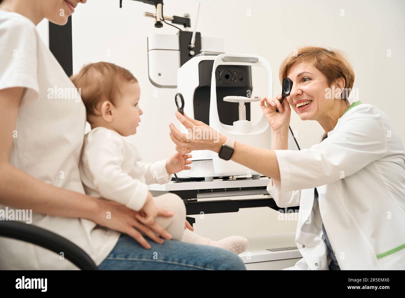 Ophthalmologist performing vision screening in child at initial ...
