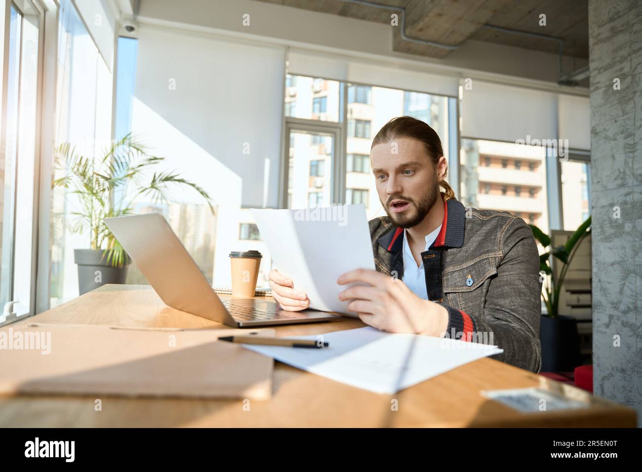 Male employee surprised while reading notes indoors Stock Photo - Alamy