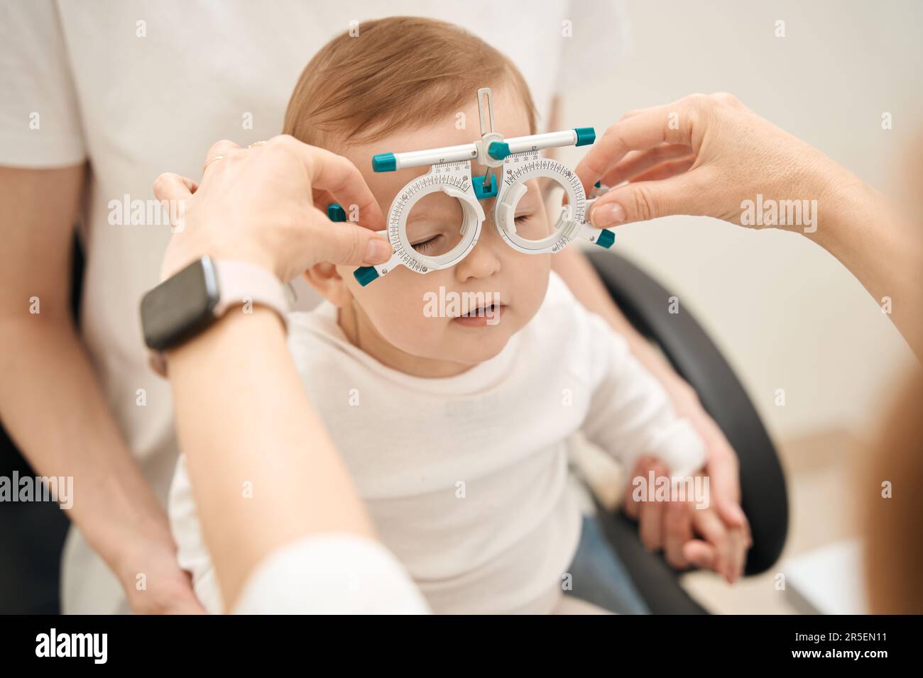 Pediatric optometrist preparing baby for visual acuity test Stock Photo ...