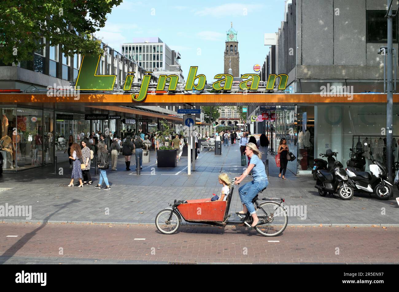 A cyclist on a cargo bike lane passes the Lijnbaan shopping precinct in ...