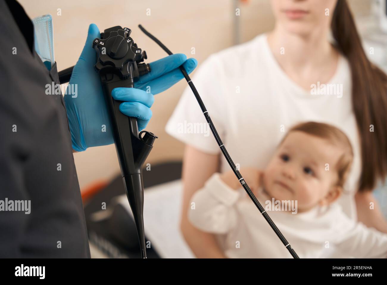 Expert endoscopist preparing infant for endoscopy procedure in mother ...