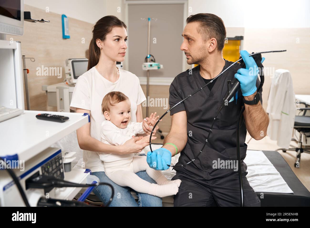 Qualified diagnostician preparing child for endoscopy in female parent ...