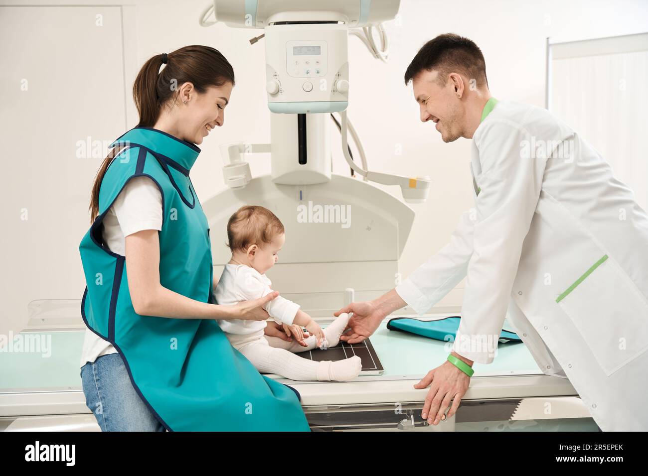 Friendly radiologist preparing child for radiography of lower limb ...