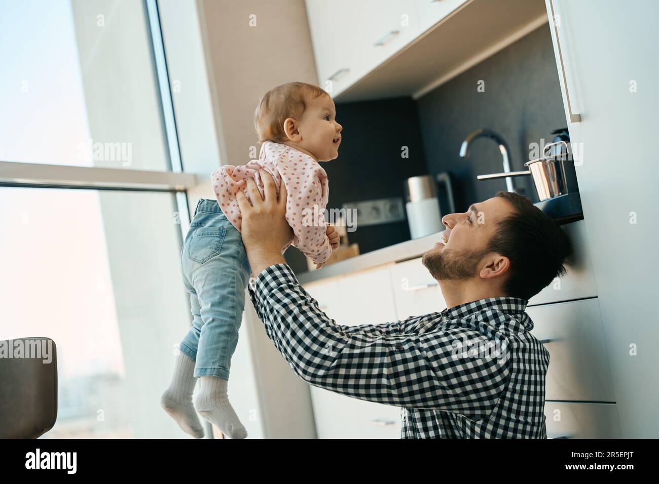 Bearded father joyfully plays with a pretty little daughter Stock Photo ...