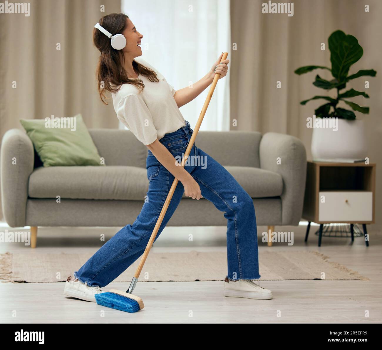 Woman Singer And Broom To Clean Living Room With Funny Dance Sweeping