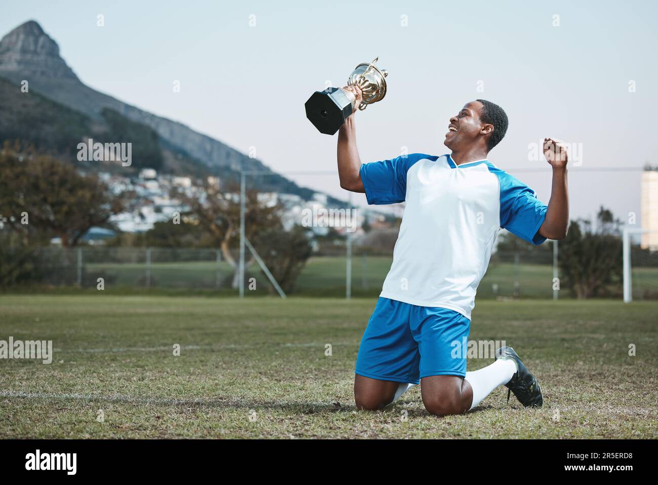 Soccer player, sports and man celebrate trophy on field for competition ...