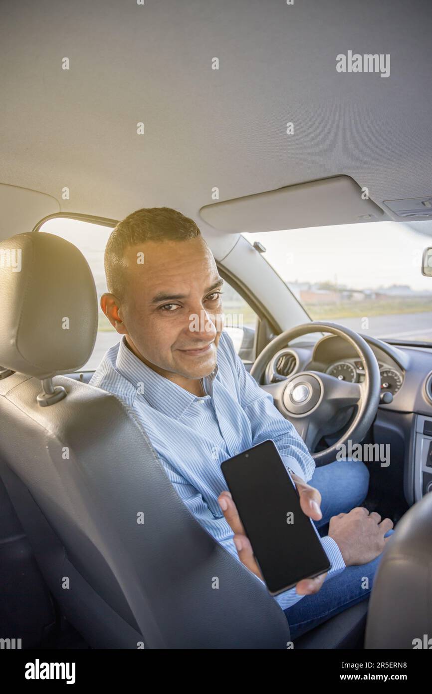 Driver shows the screen of his mobile phone inside his car Stock Photo ...