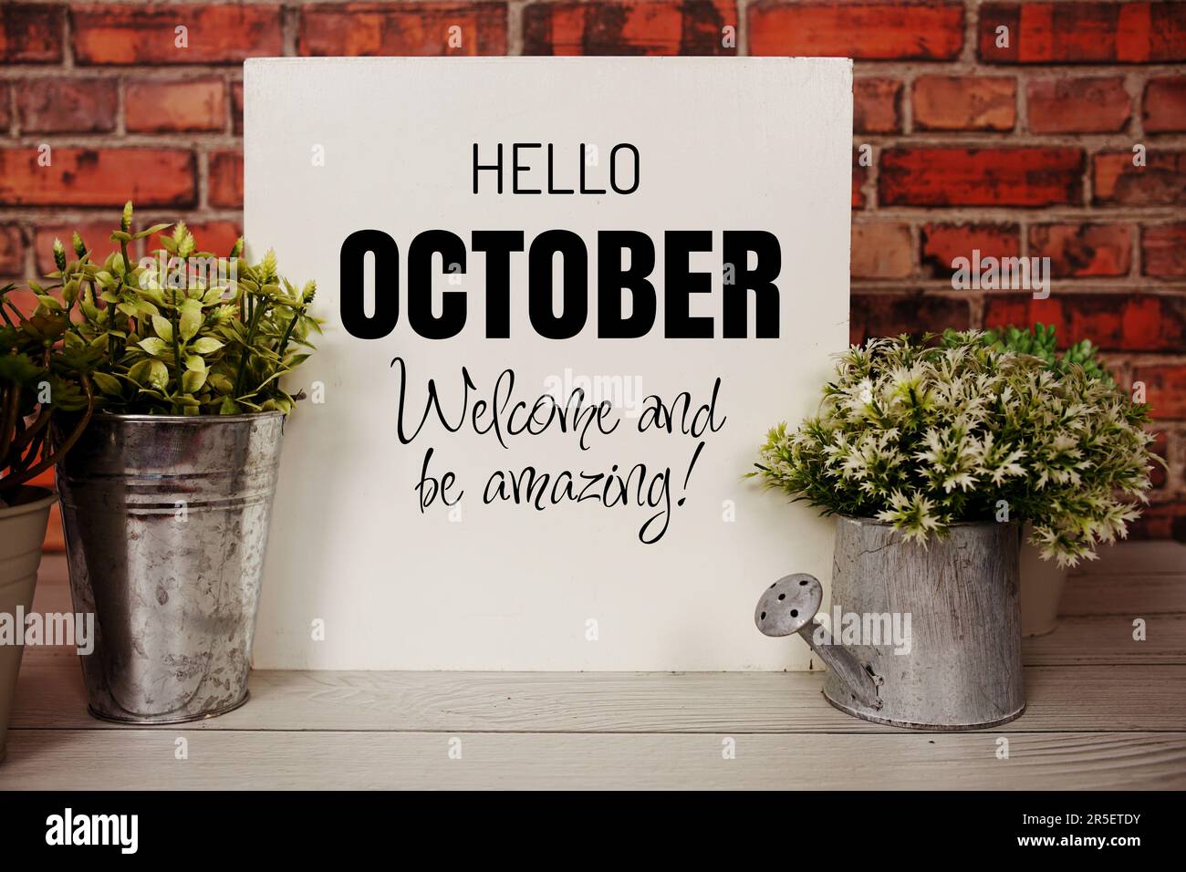 Hello October text message with artificial plant in metal vase ...