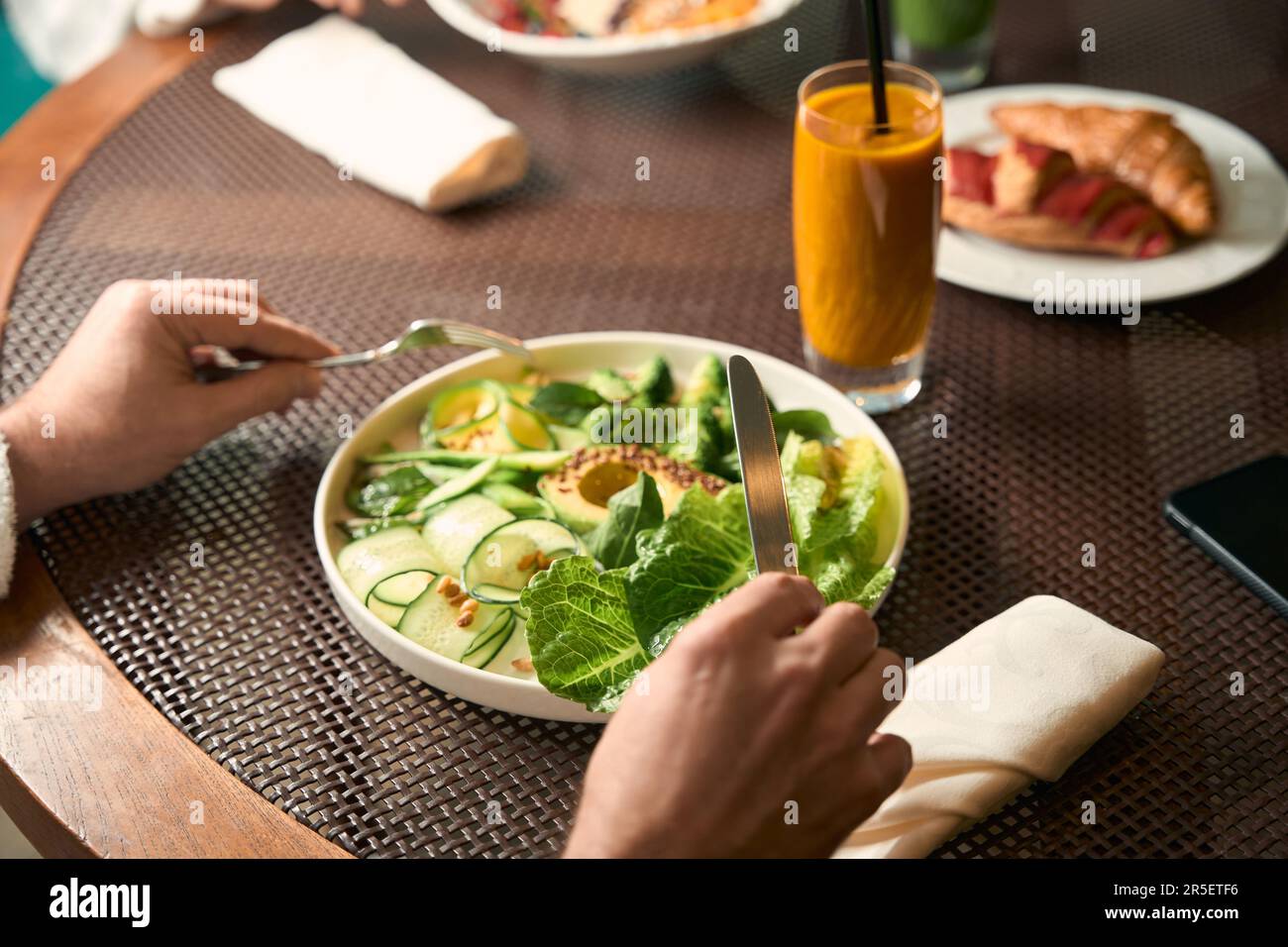 Man having healthy lunch at round steel mesh table Stock Photo - Alamy
