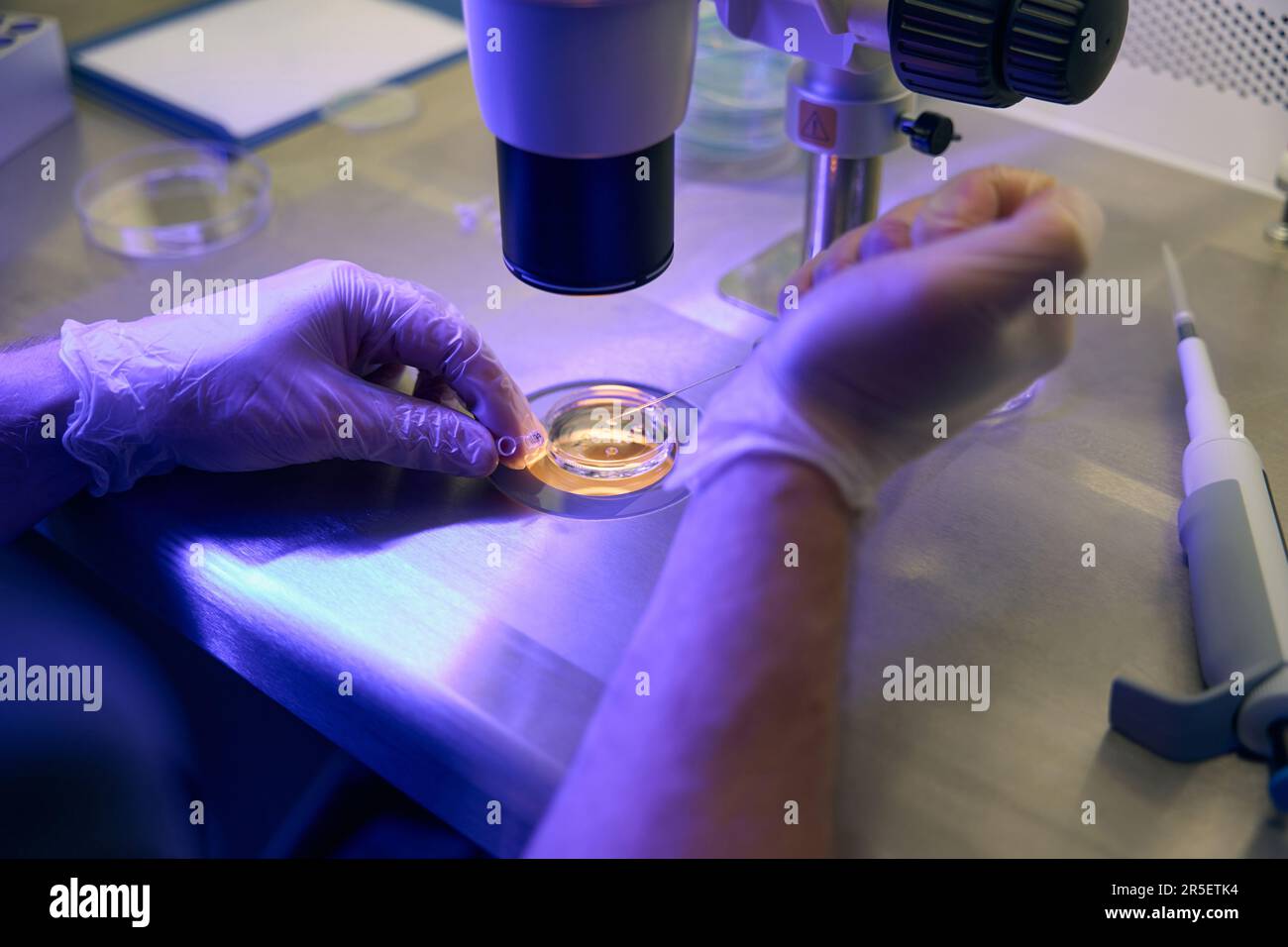 Reproductology laboratory technician taking liquid from test tube with ...