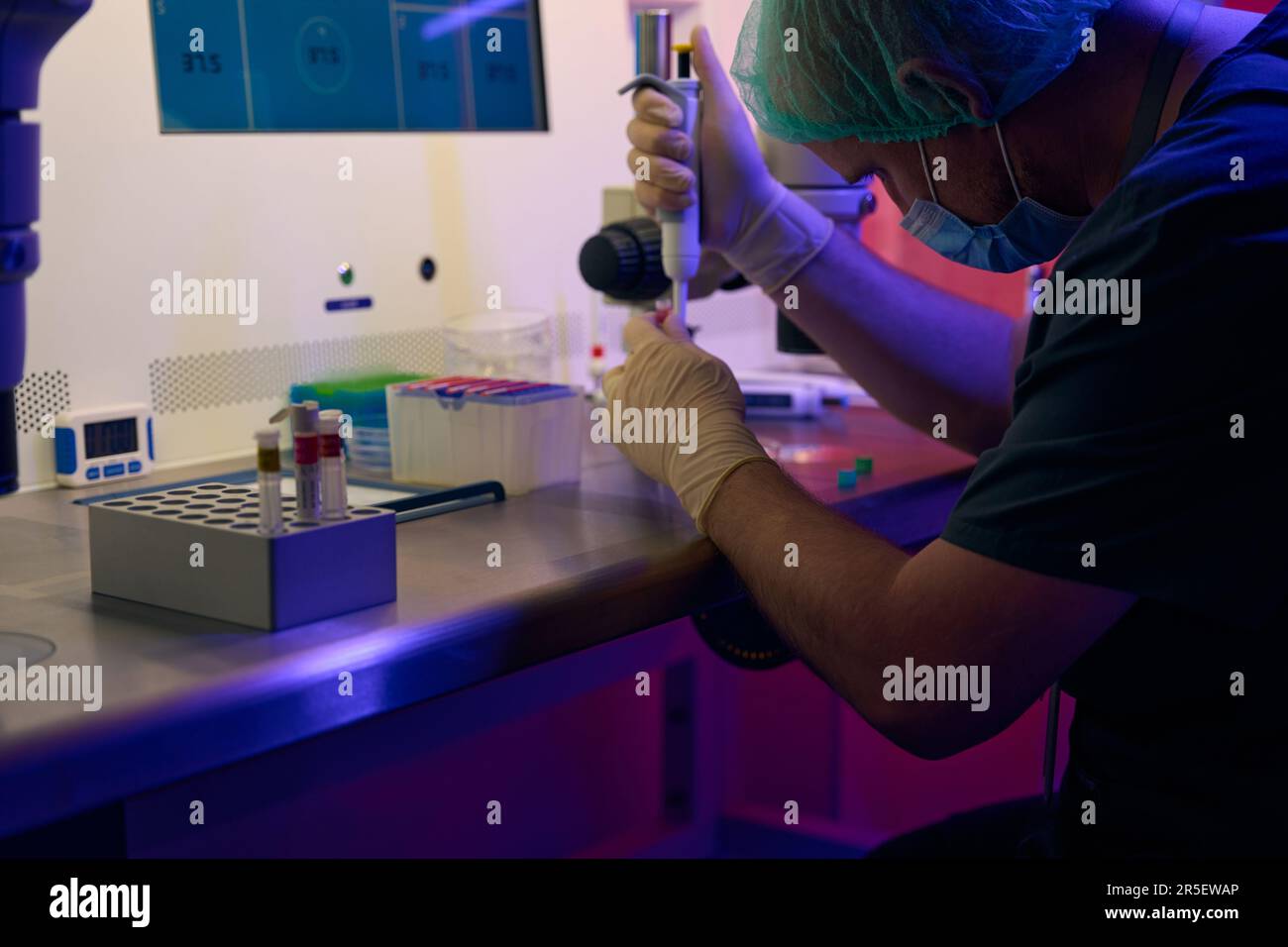 Biolaboratory worker adding fluid sample with micropipette Stock Photo ...