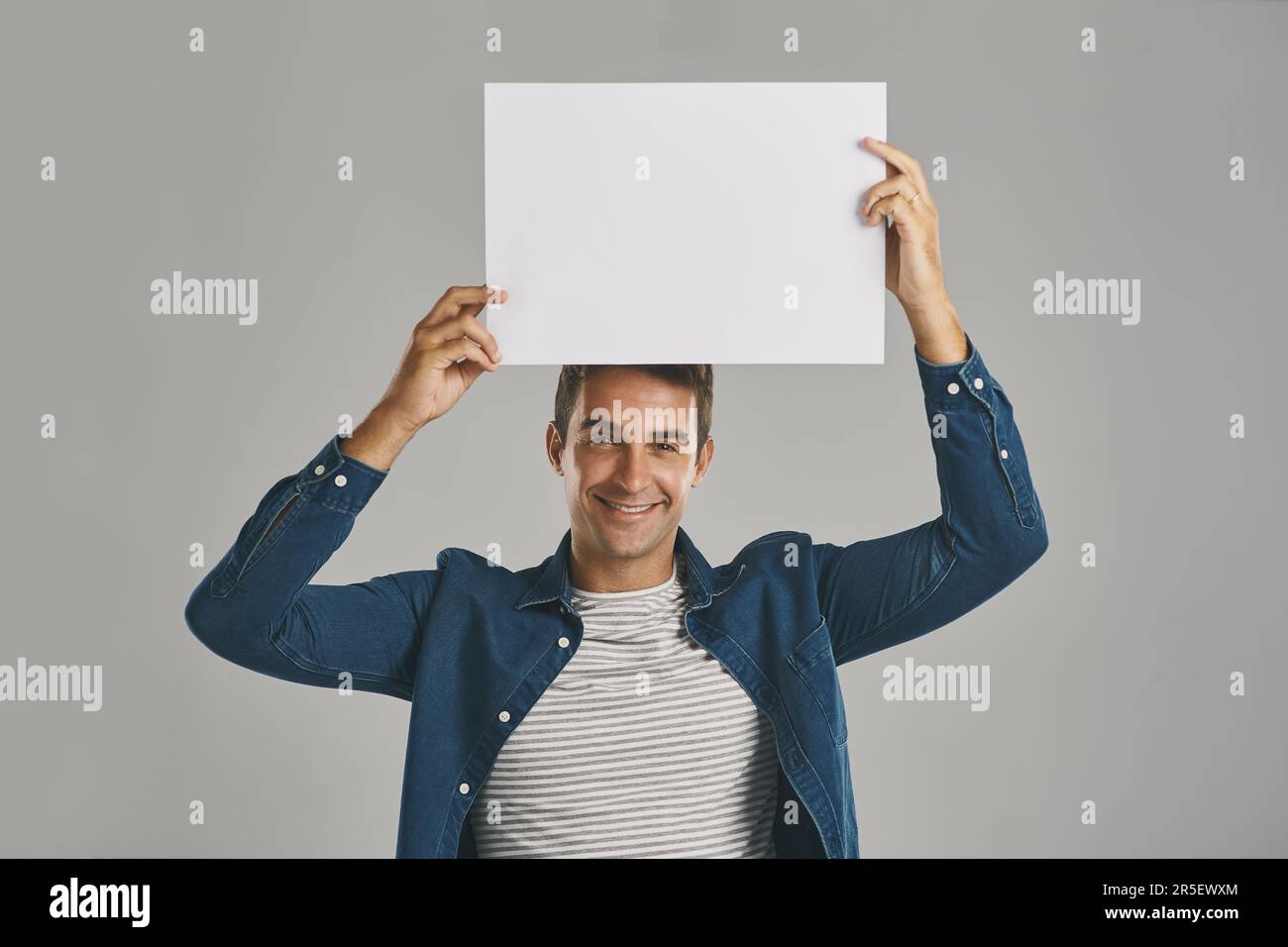 Heres the big news. Studio portrait of a young man holding a blank ...