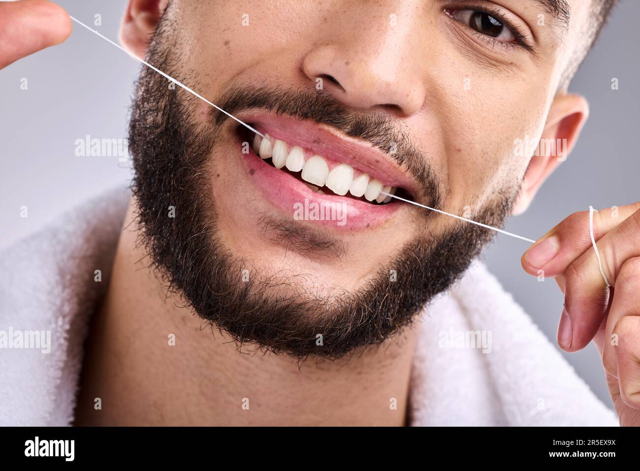 Face, man and flossing teeth for dental health in studio isolated on a ...