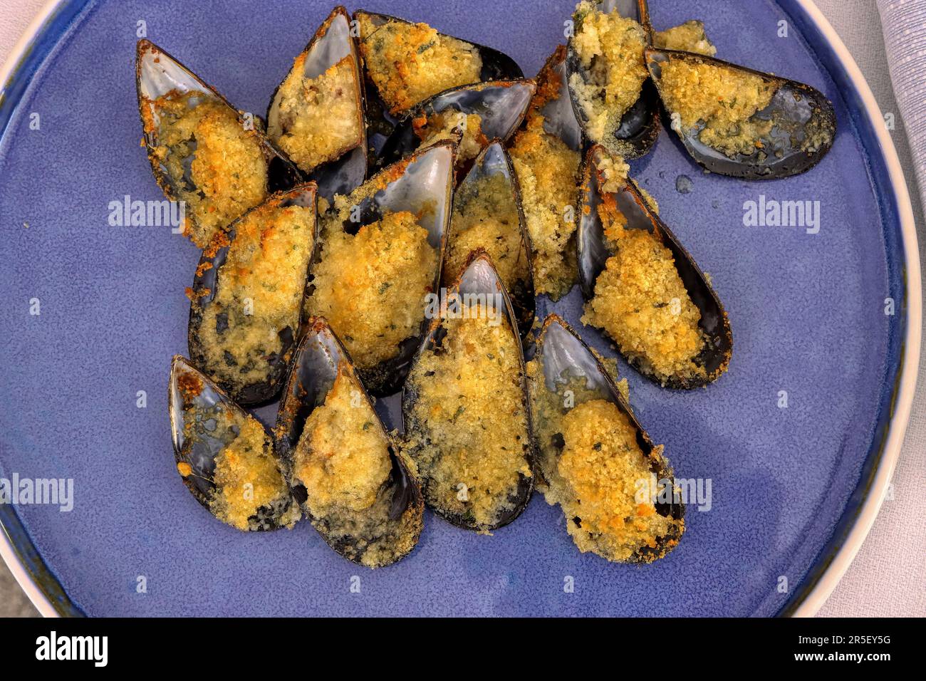 Plate of mussels au gratin. Mussels covered in wine and stuffed with ...