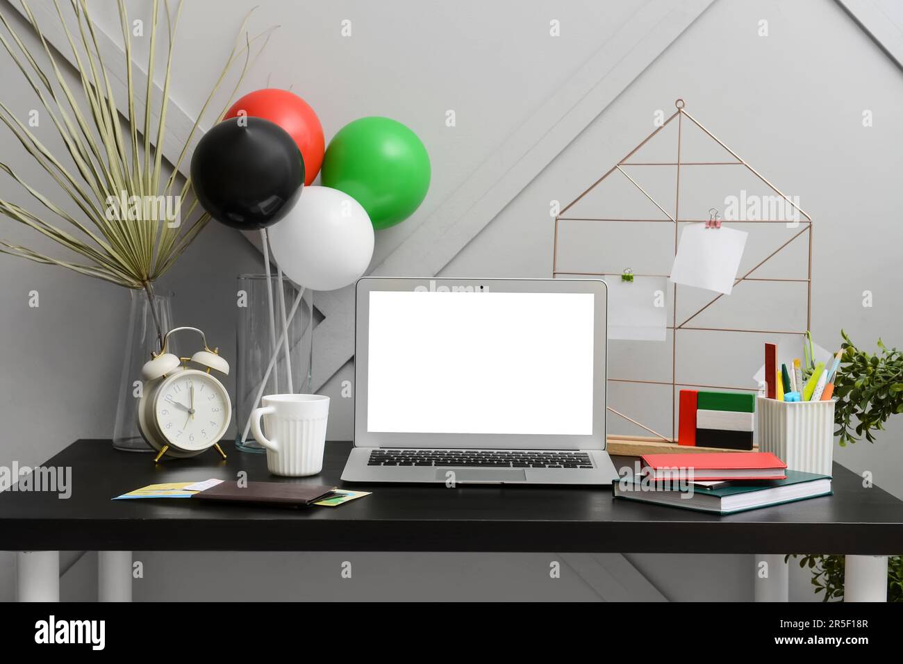 Modern workplace with balloons and blocks in colors of UAE flag near ...