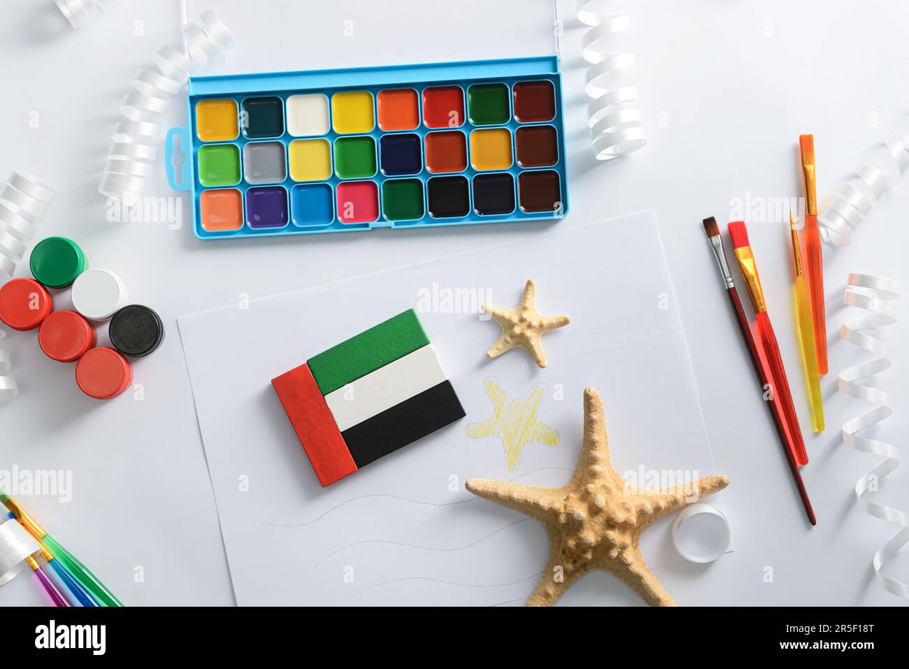UAE flag made of blocks, paper sheet, starfishes, brushes and paints on ...