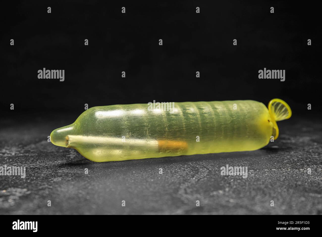 Inflated condom with cigarette inside on dark background. Stop smoking ...
