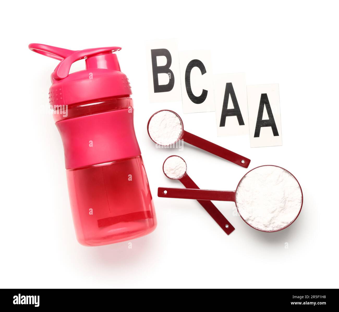 Bottle of water, scoops with amino acid supplement and text BCAA on ...