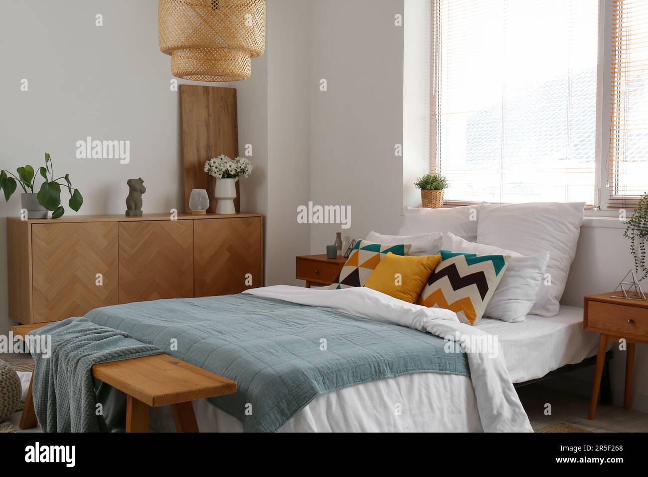Interior of bedroom with wooden cabinet and cozy bed near window Stock ...
