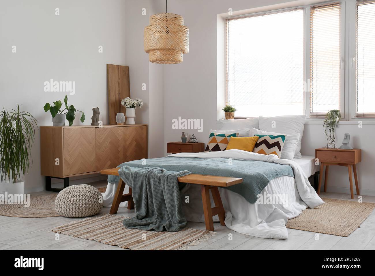 Interior of bedroom with wooden cabinet and cozy bed near window Stock ...