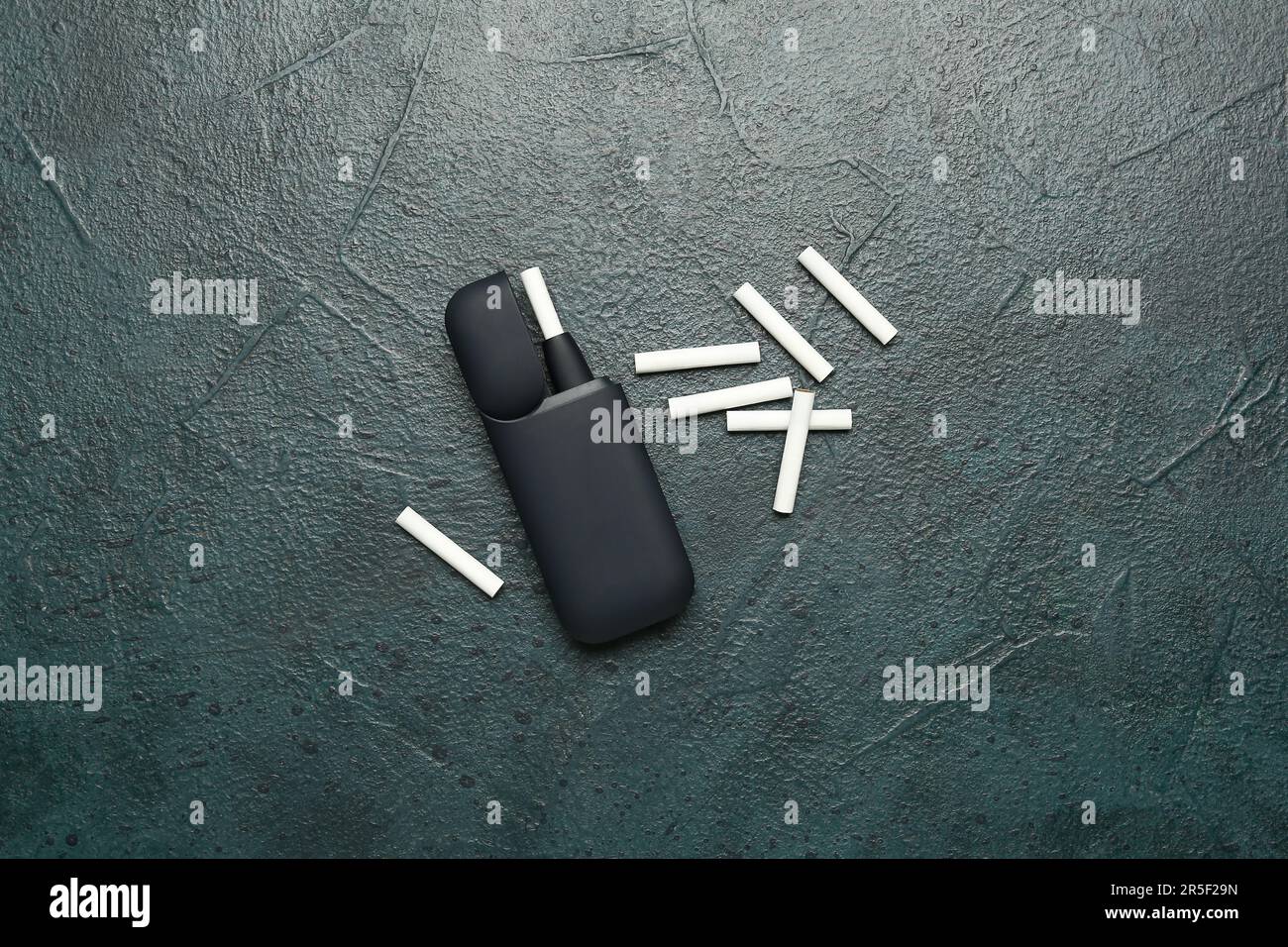 Modern electronic cigar with sticks on dark grunge table Stock Photo ...