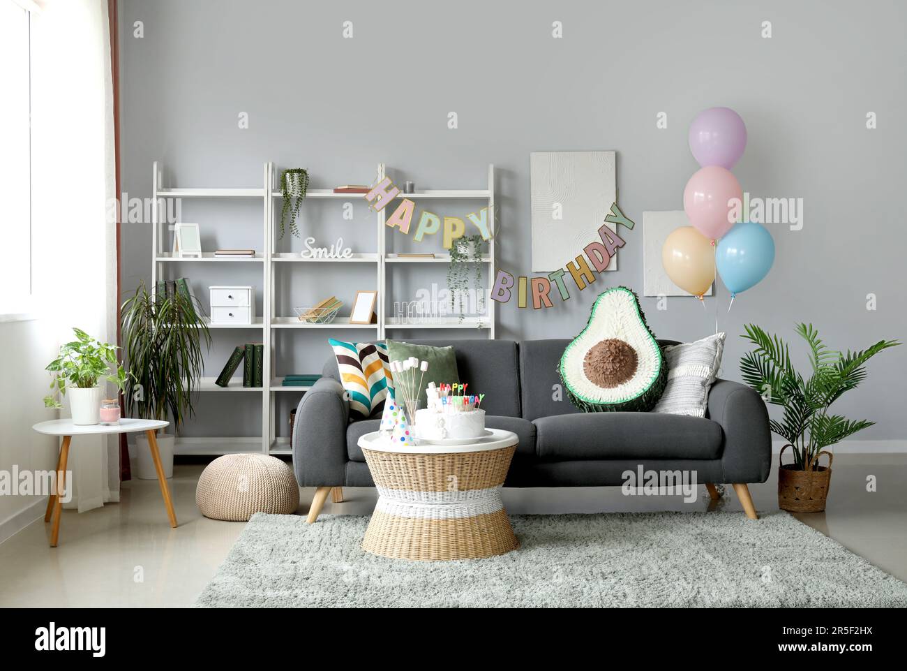 Interior of living room with birthday cake, balloons and pinata on grey ...