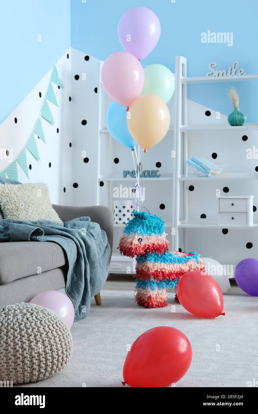 Interior of living room decorated for birthday with balloons, pinata ...