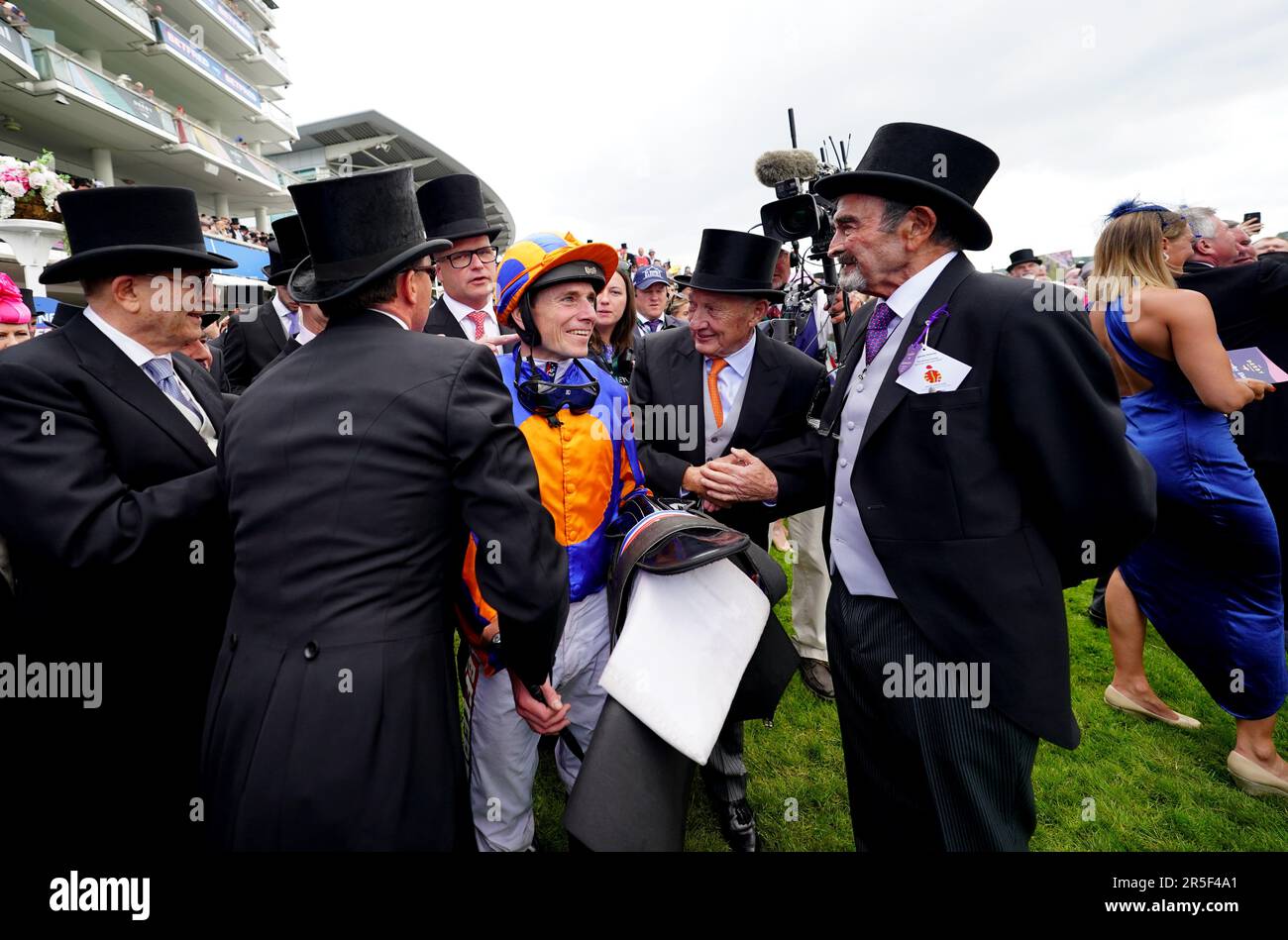 Trainer Ryan Moore (centre) celebrates winning The Betfred Derby on ...