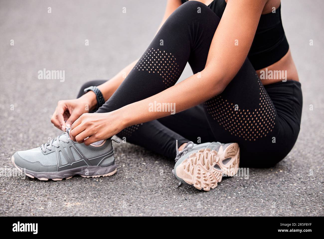 Fitness, woman tying shoes and sitting road for safety during outdoor ...