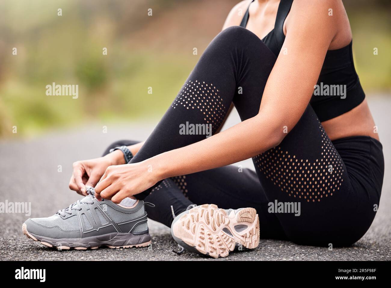 Fitness, woman tying sneakers and sitting on road for safety during ...