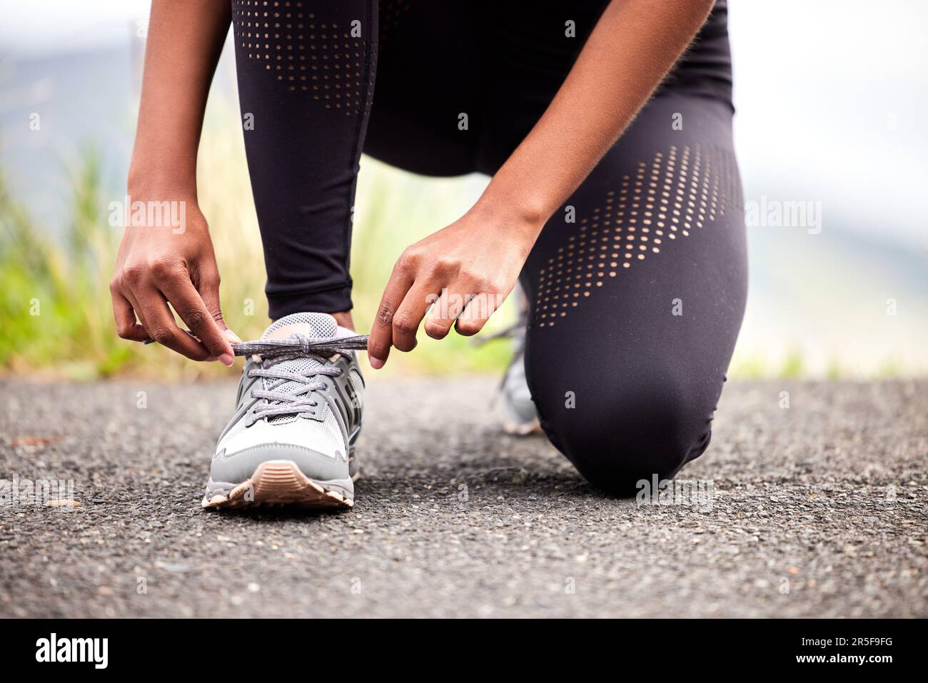 Sport, feet of woman tying sneakers and runner on road for safety ...